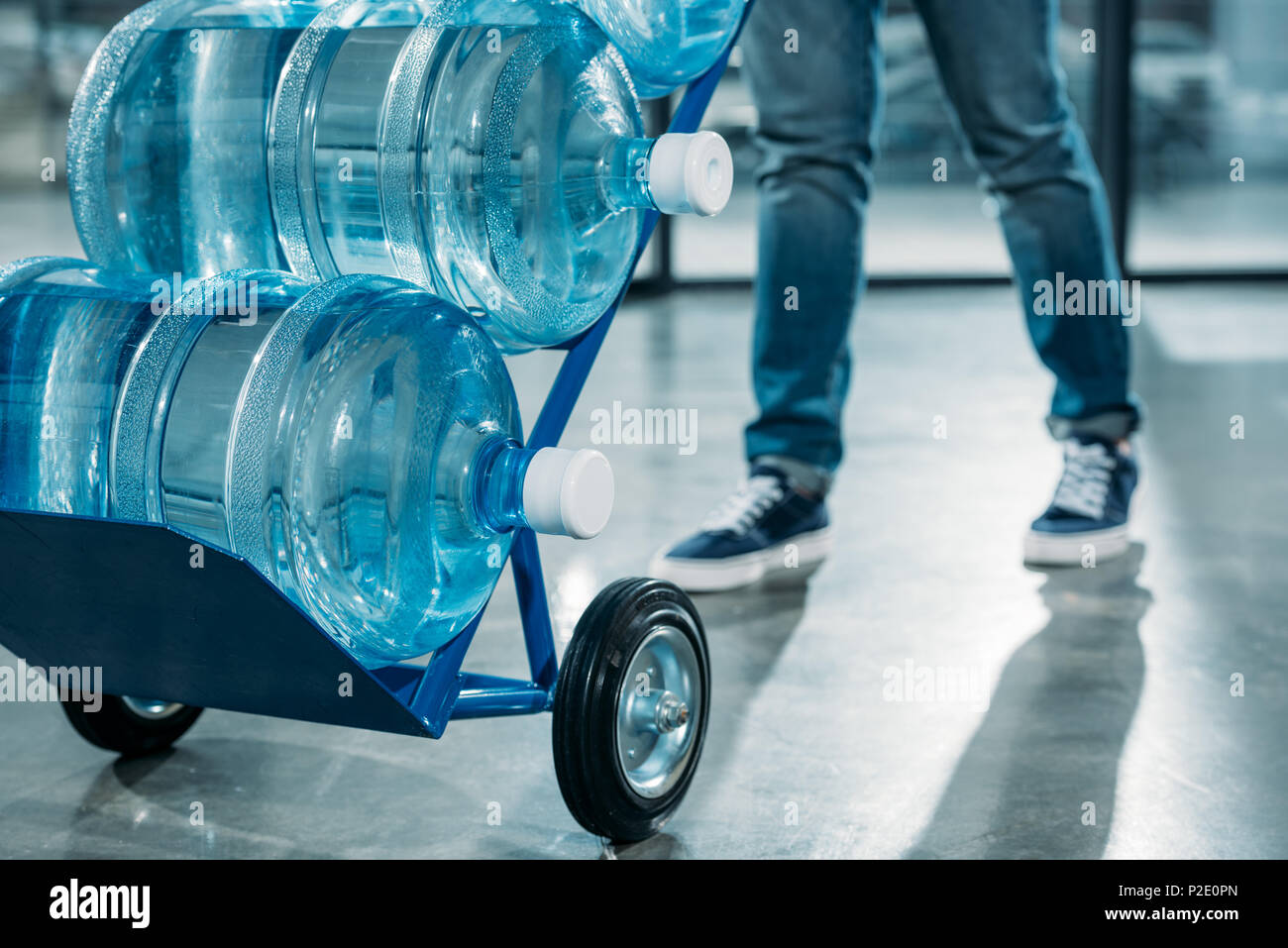 Close-up view of loader man pushing cart with water bottles Stock Photo ...