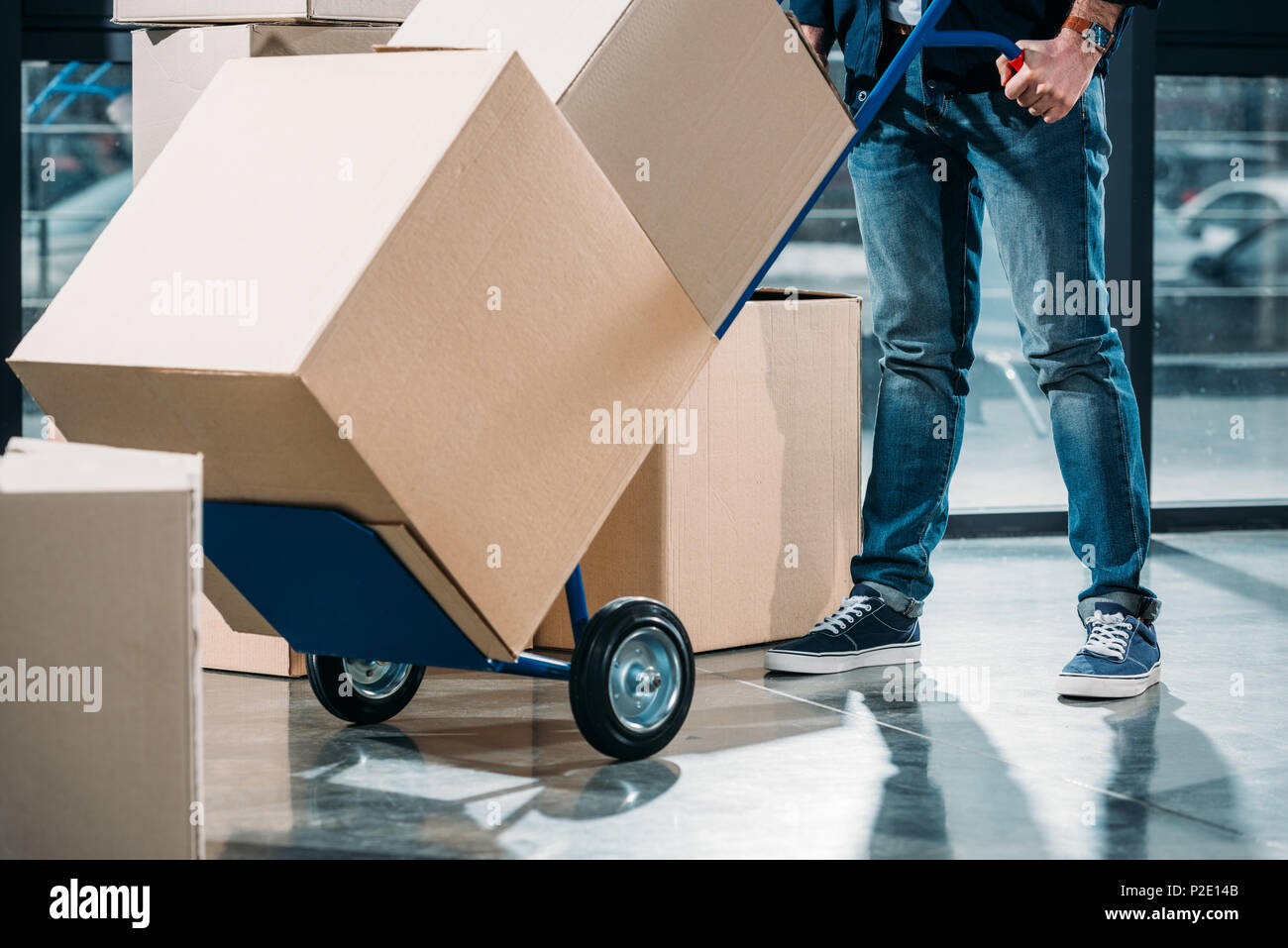 Close-up view of delivery man carrying boxes on cart Stock Photo - Alamy