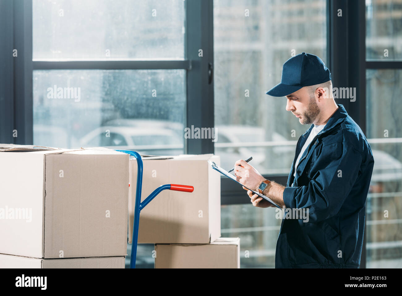 Courier checking cardboard boxes and cargo declaration Stock Photo - Alamy
