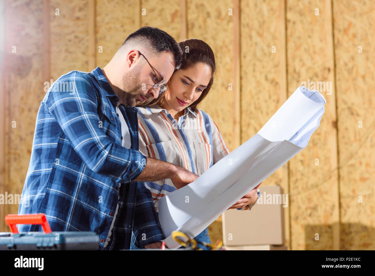Team of engineers looking at project blueprint Stock Photo - Alamy