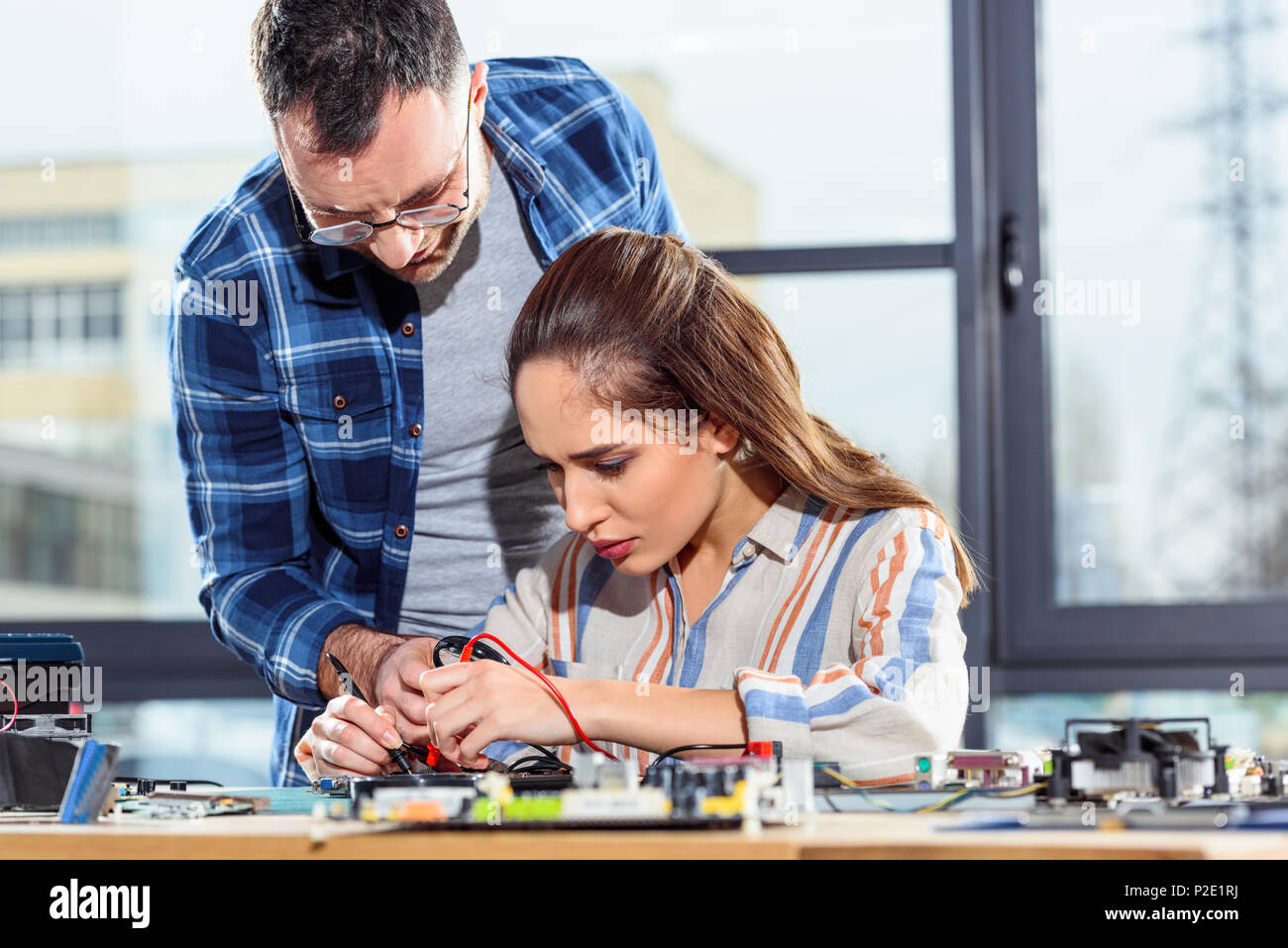 Woman and man engineers testing circuit board Stock Photo - Alamy