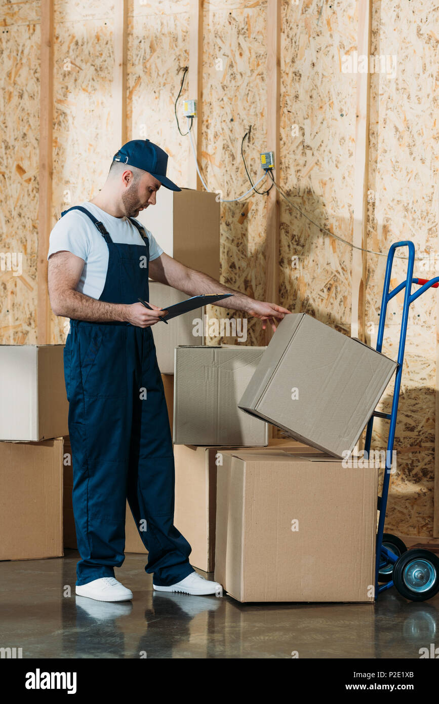 Courier checking cardboard boxes and cargo declaration Stock Photo - Alamy