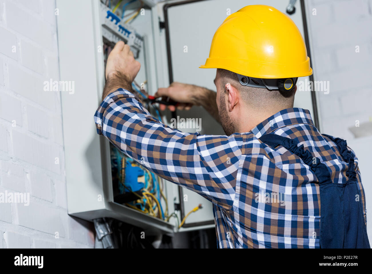 Male electrician checking wires in electrical box Stock Photo - Alamy