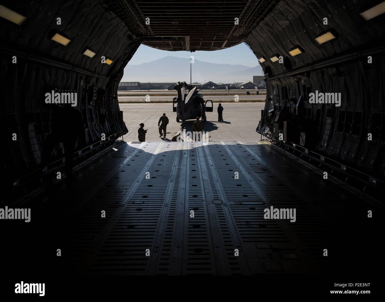 A Sikorsky UH-60 Blackhawk is guided into a C-5 Galaxy for transport ...
