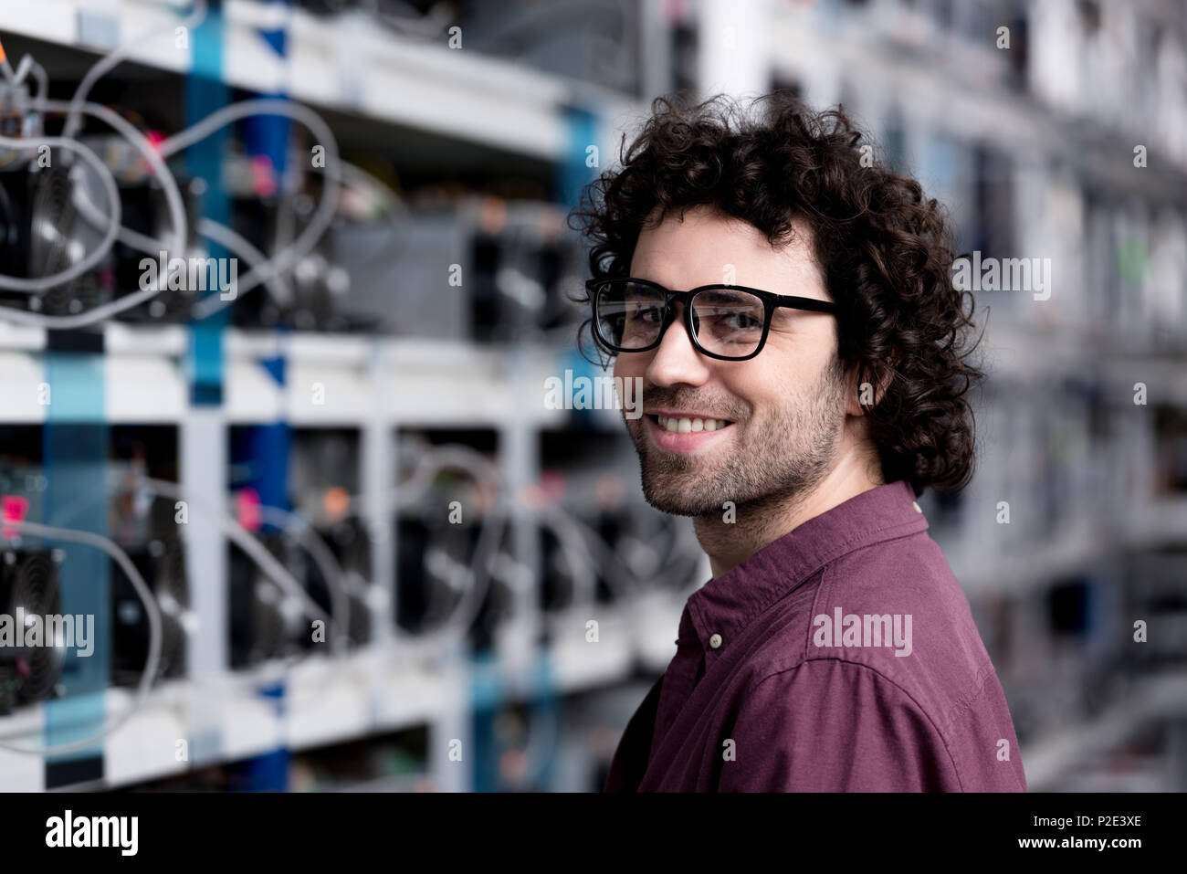 happy young computer engineer at cryptocurrency mining farm looking at ...