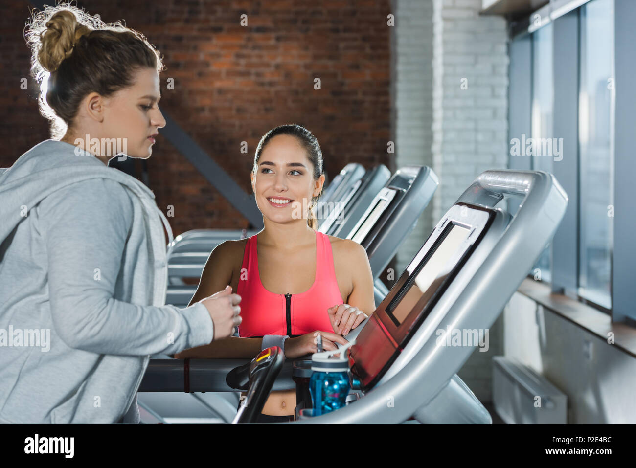 overweight woman training on treadmill while trainer watching her Stock ...