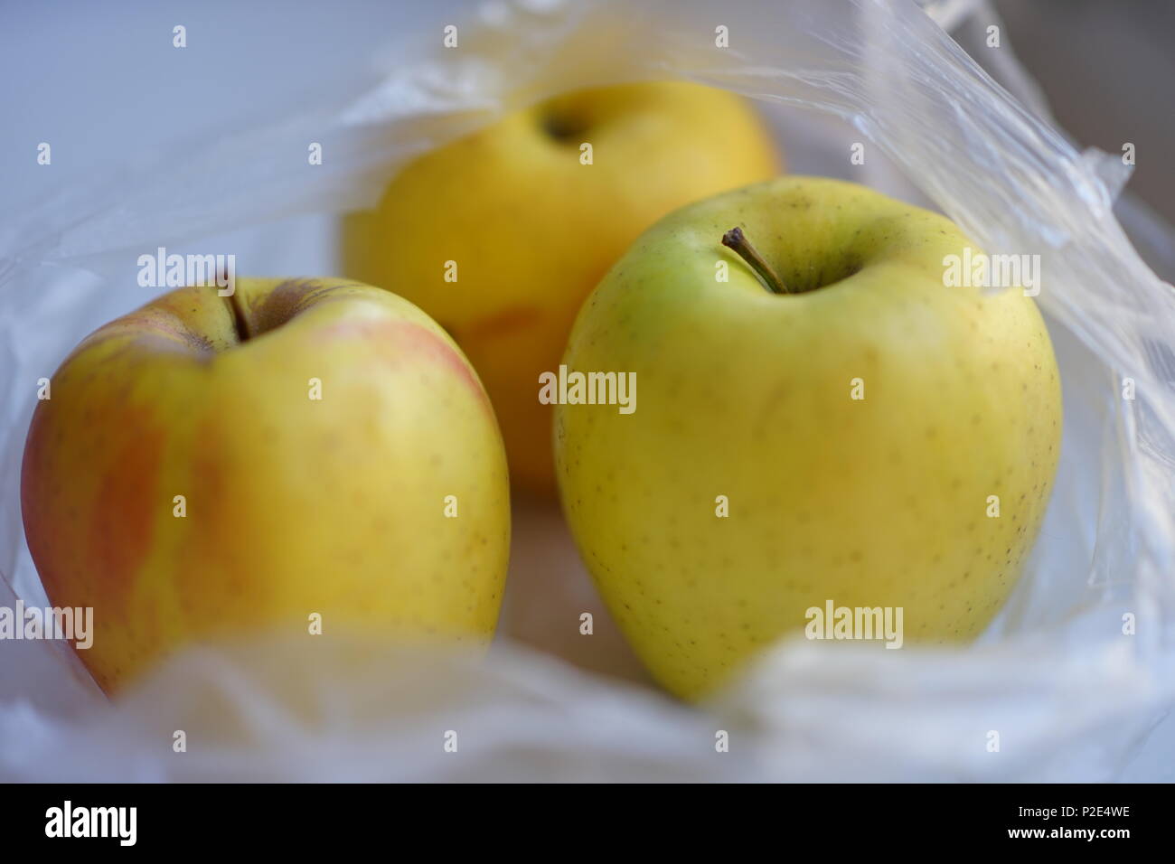 three ripe apples in a transparent package Stock Photo - Alamy