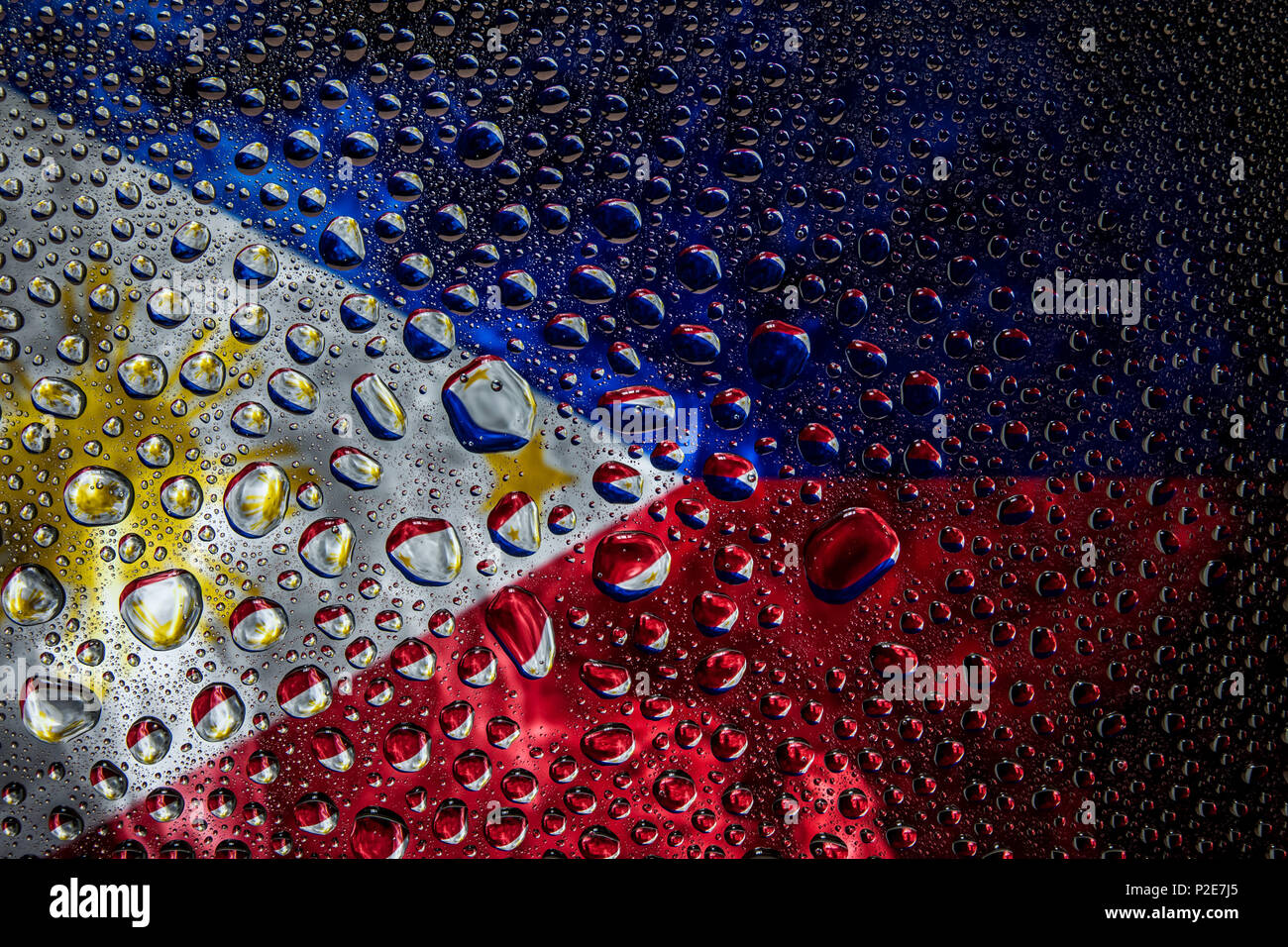Close-up of a drop of water against a background of the national flag ...