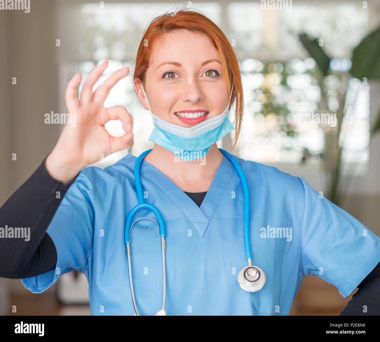 Medical professional woman with stethoscope doing ok sign with fingers ...