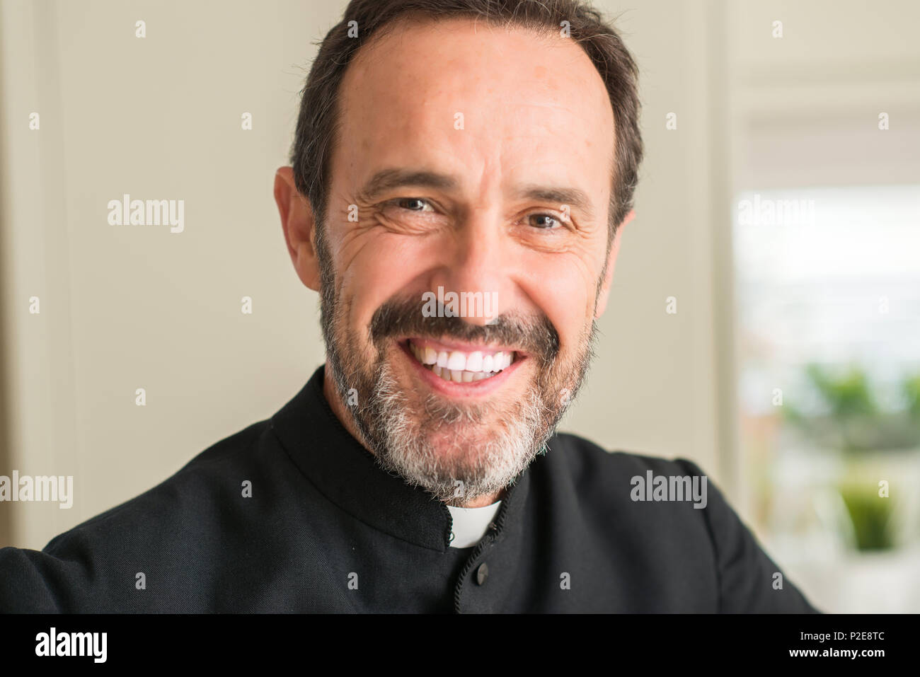 Christian priest man with a happy face standing and smiling with a ...