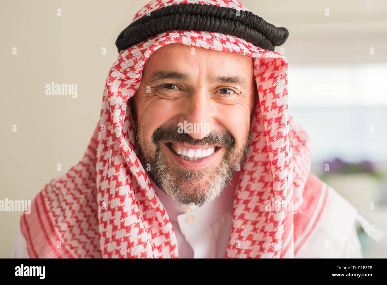 Middle age arabian man at home with a happy face standing and smiling ...