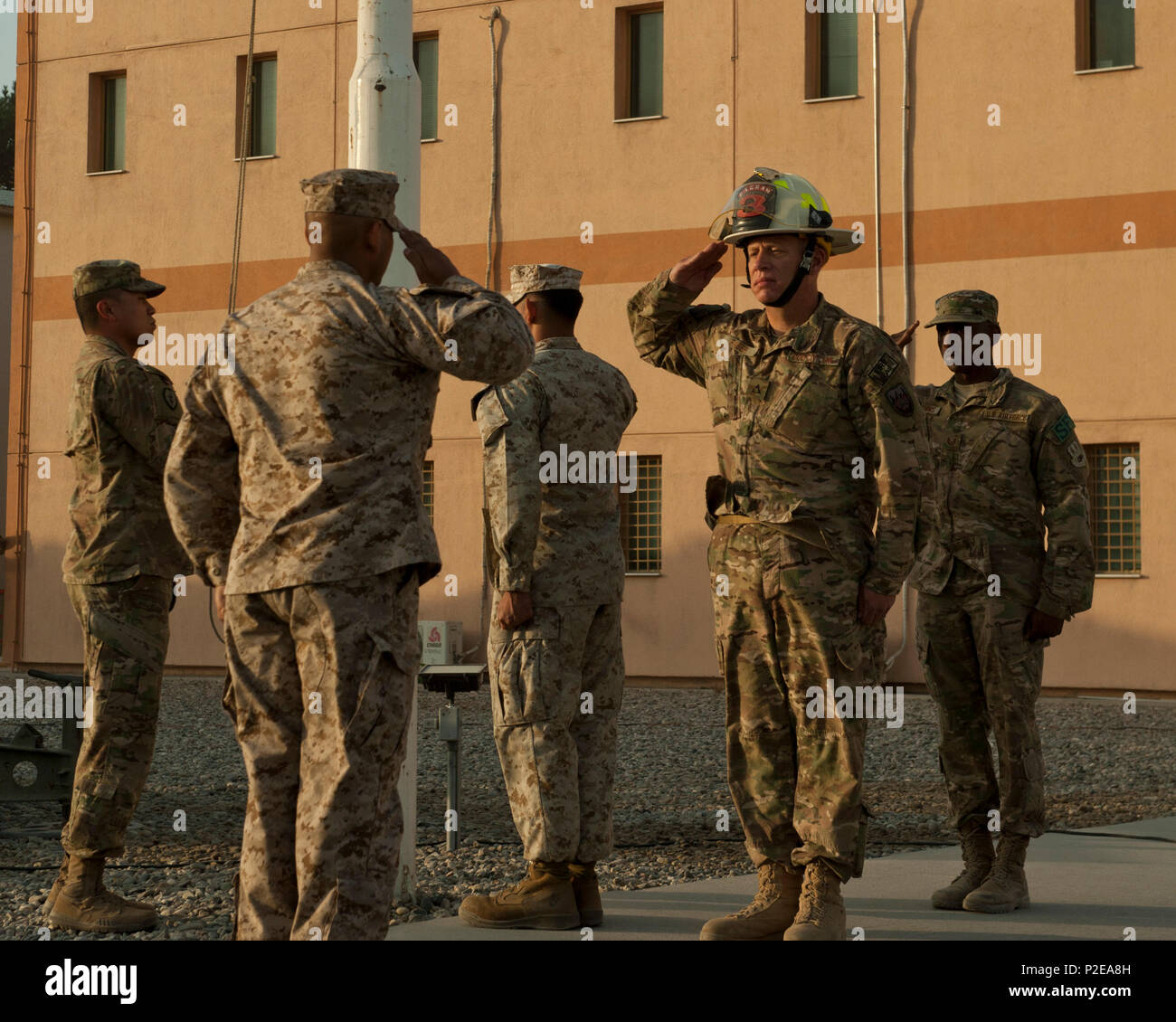 A joint service honor guard salutes the flag during a retreat ceremony ...