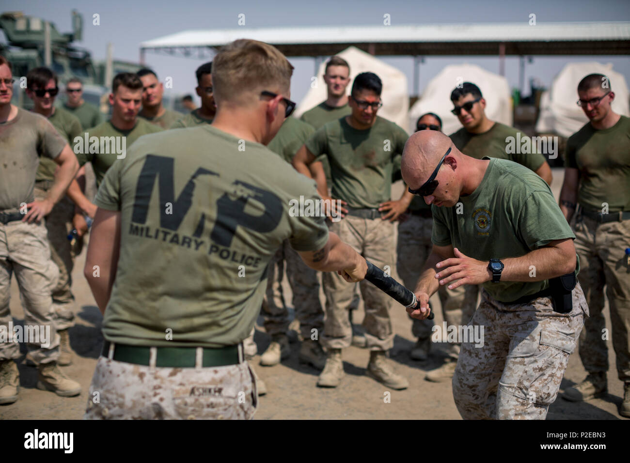 U.S. Marine Corps Cpl. Erik Doenitz (right), a non-lethal weapons ...