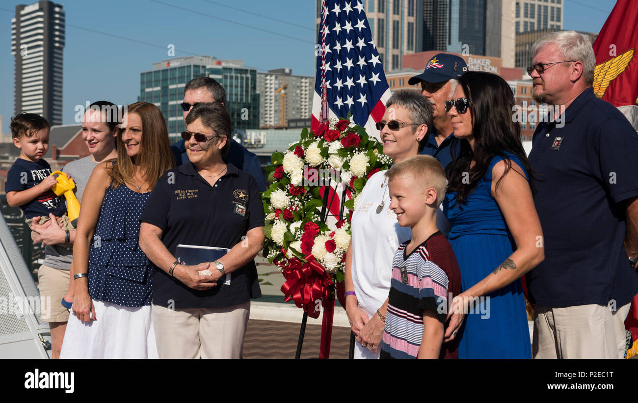 Jana Rigsby stands with family members next to the American flag and ...