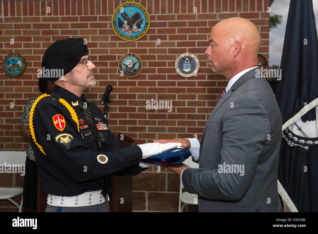 A veteran Honor Guard commander presents the American flag to the mayor ...