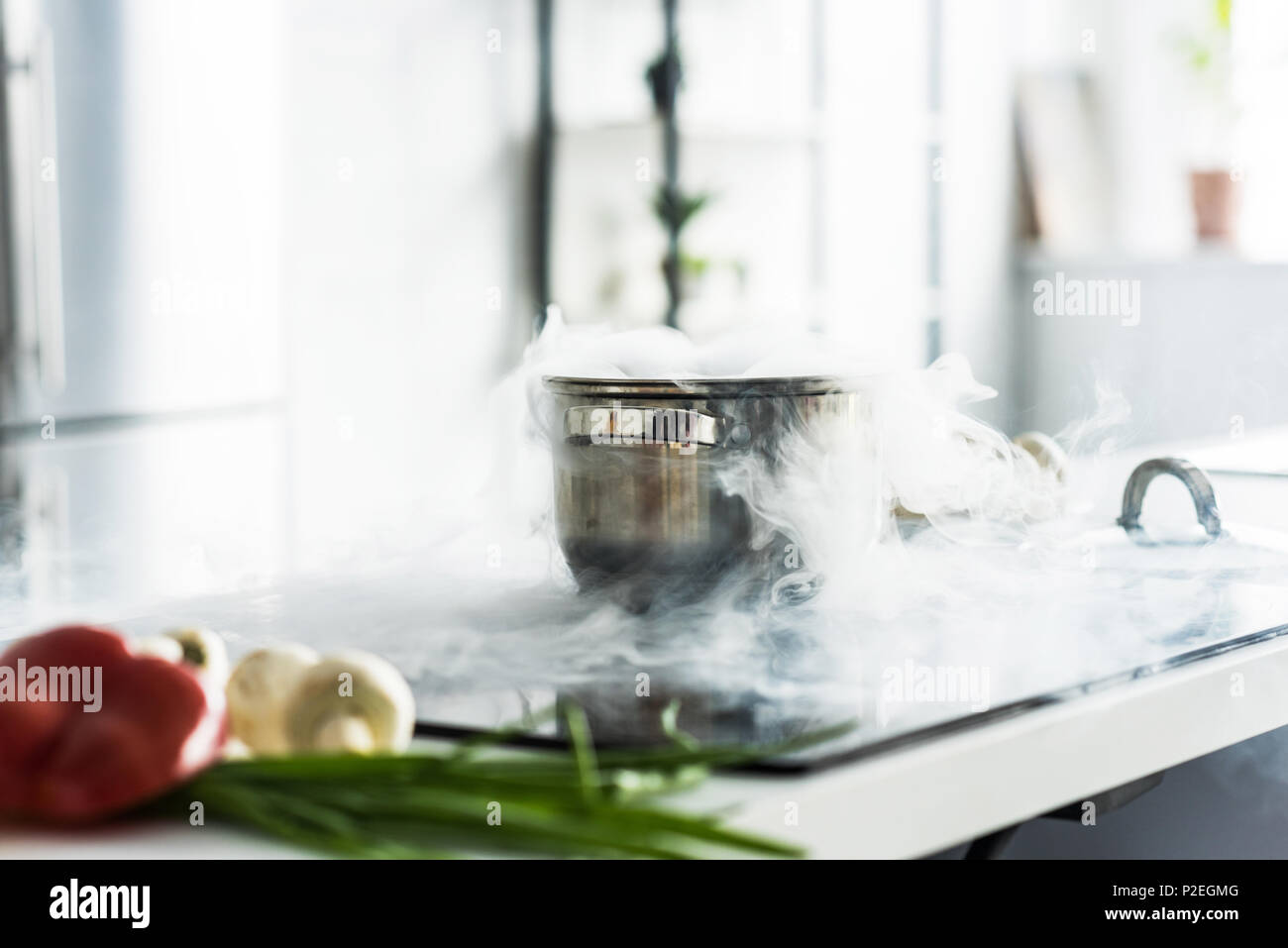 pan with steam on electric stove in kitchen Stock Photo - Alamy