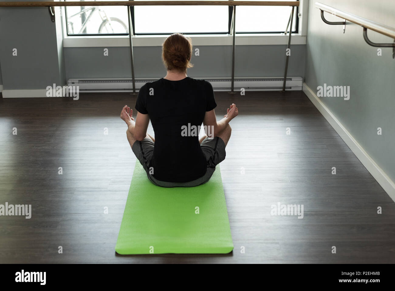 Rear view of man practicing yoga Stock Photo - Alamy