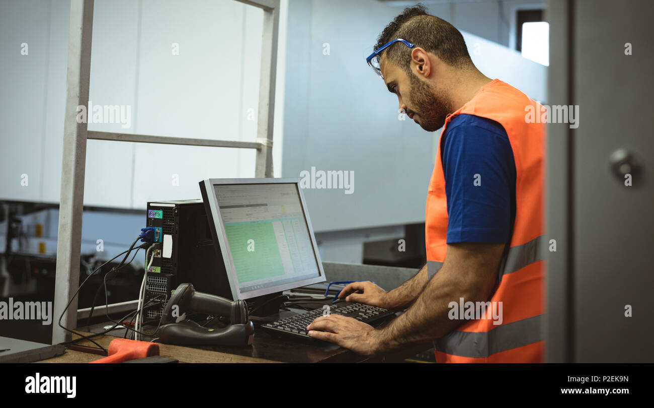 Male worker working on computer Stock Photo - Alamy