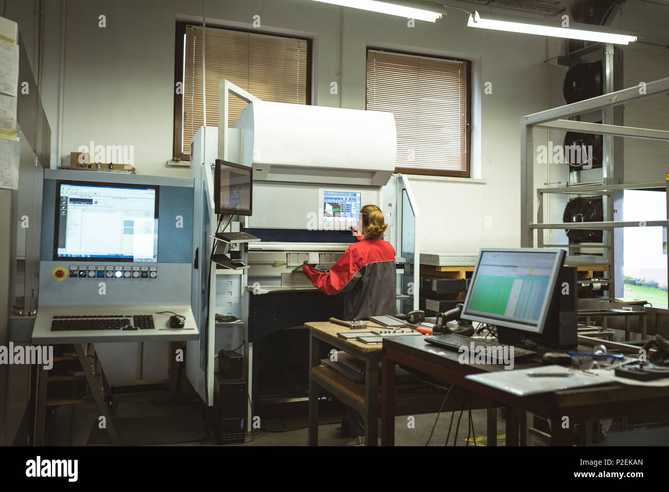 Female worker checking a machine Stock Photo - Alamy