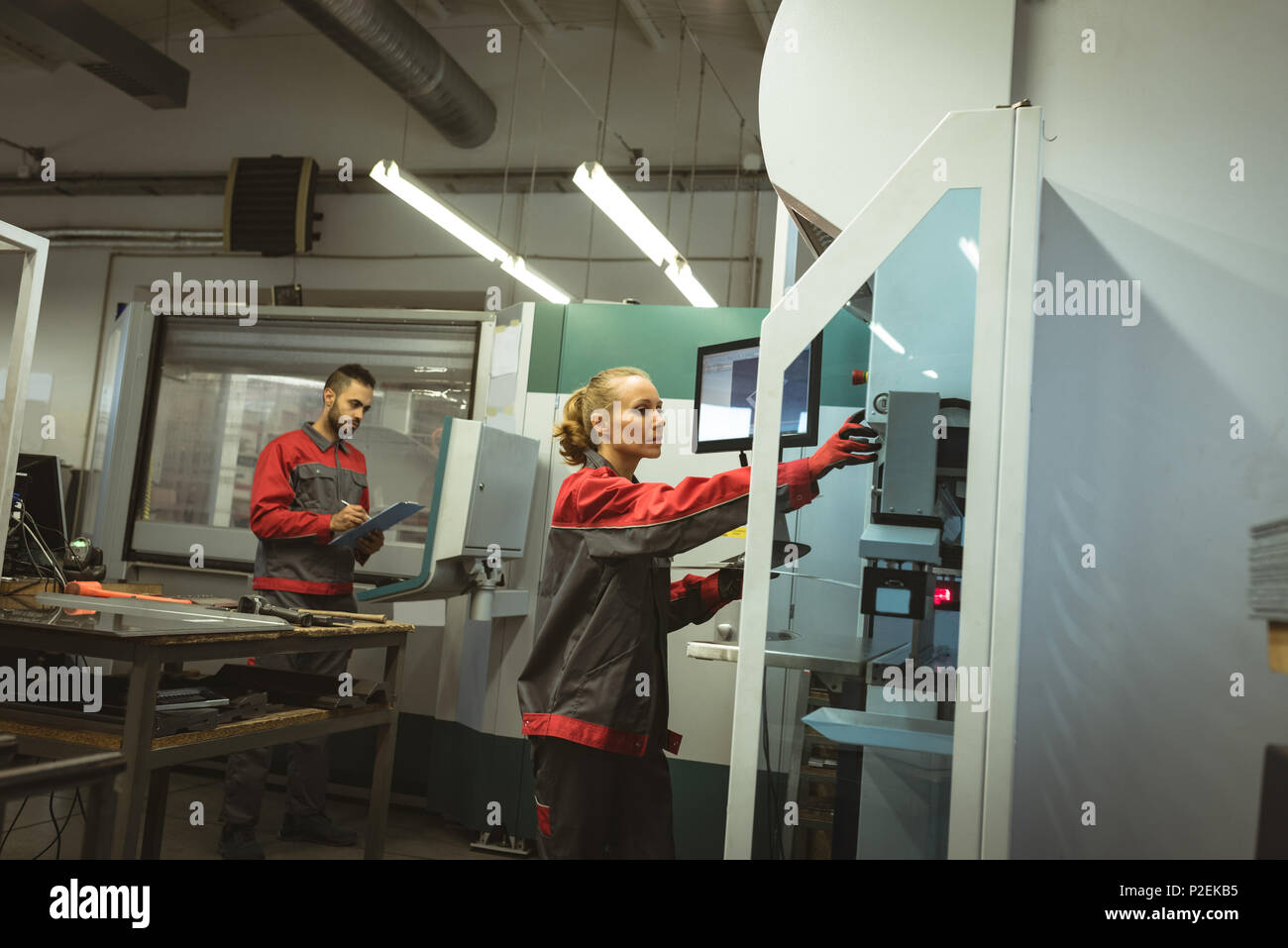 Two workers checking machine Stock Photo - Alamy