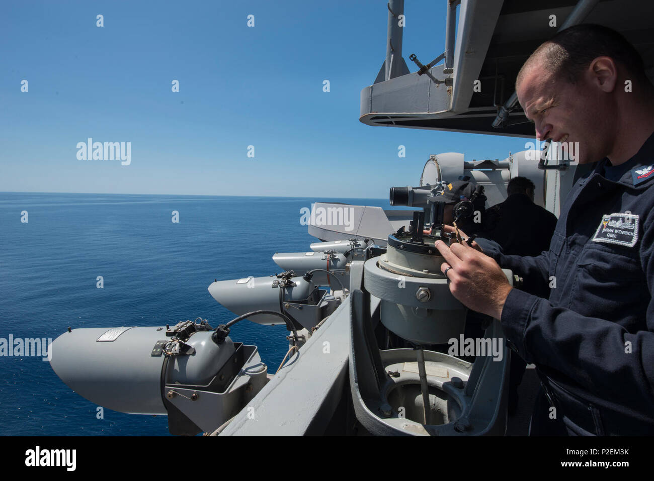 A Quartermaster 2nd Class takes a navigational reading using a bearing ...