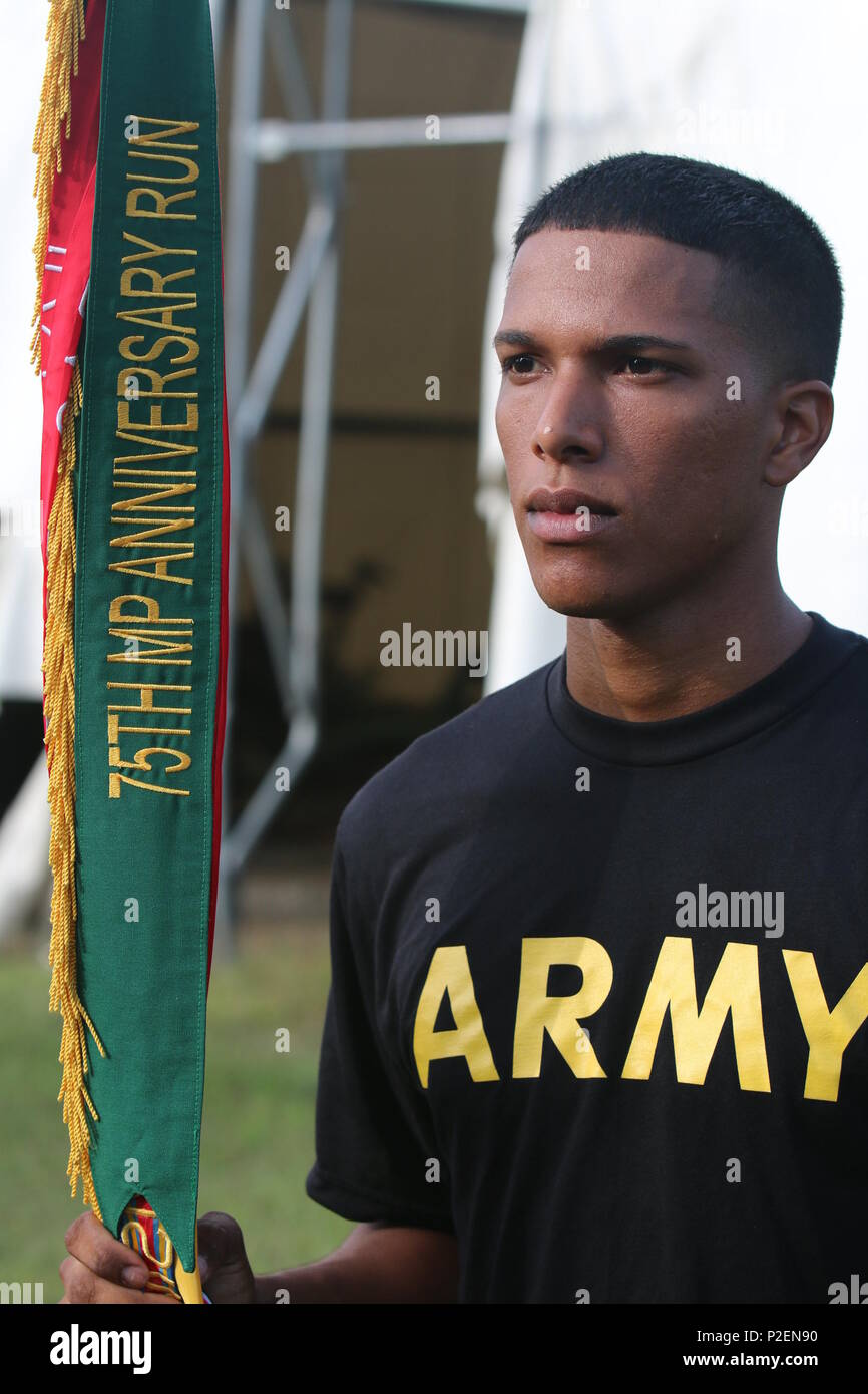 Spc. Luis Chala displays a new guide-on streamer commemorating the 75th ...