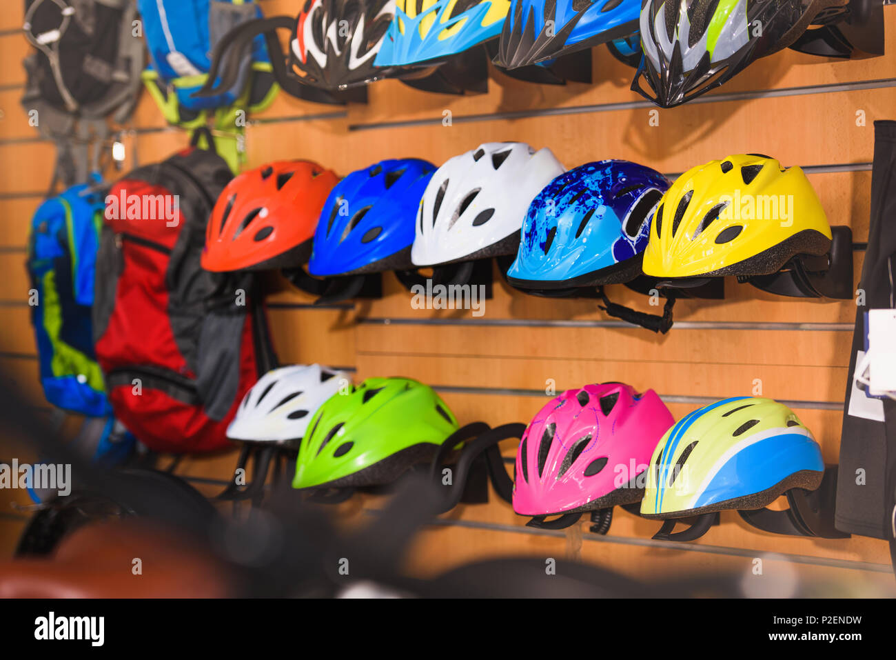 various colorful helmets displayed in bike shop Stock Photo - Alamy