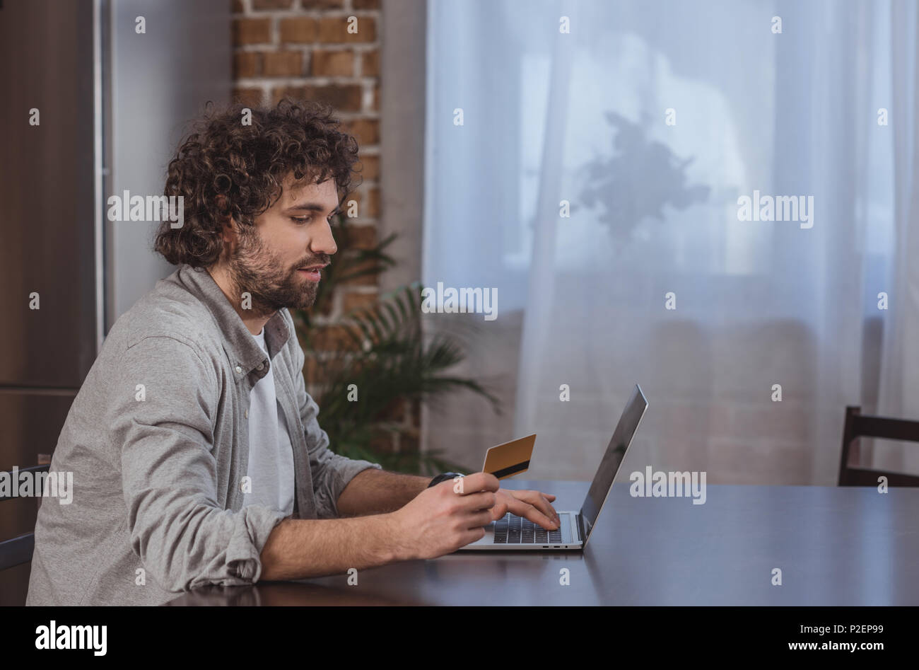 side view of handsome man shopping online at home Stock Photo - Alamy