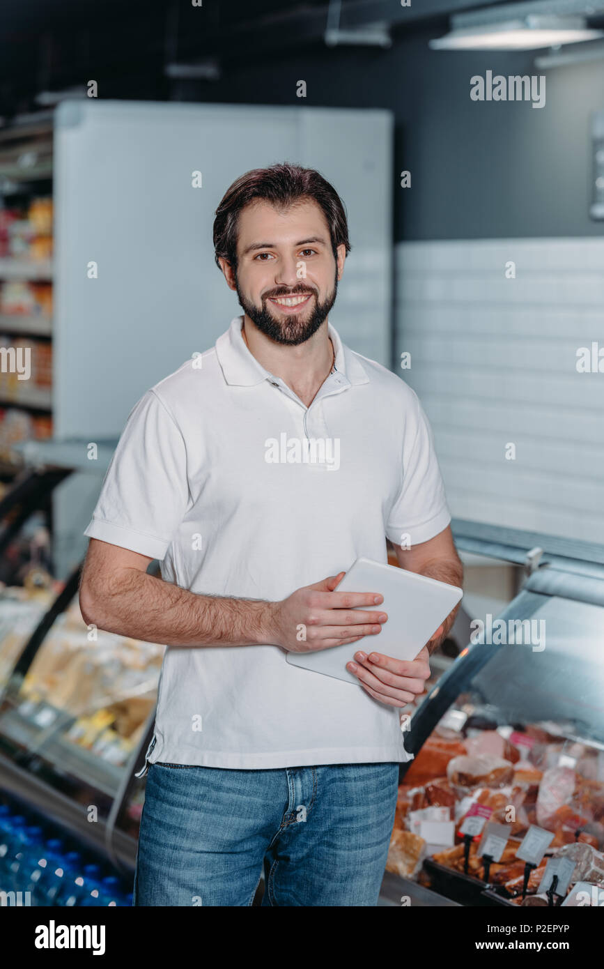 portrait of smiling shop assistant with tablet in hypermarket Stock ...