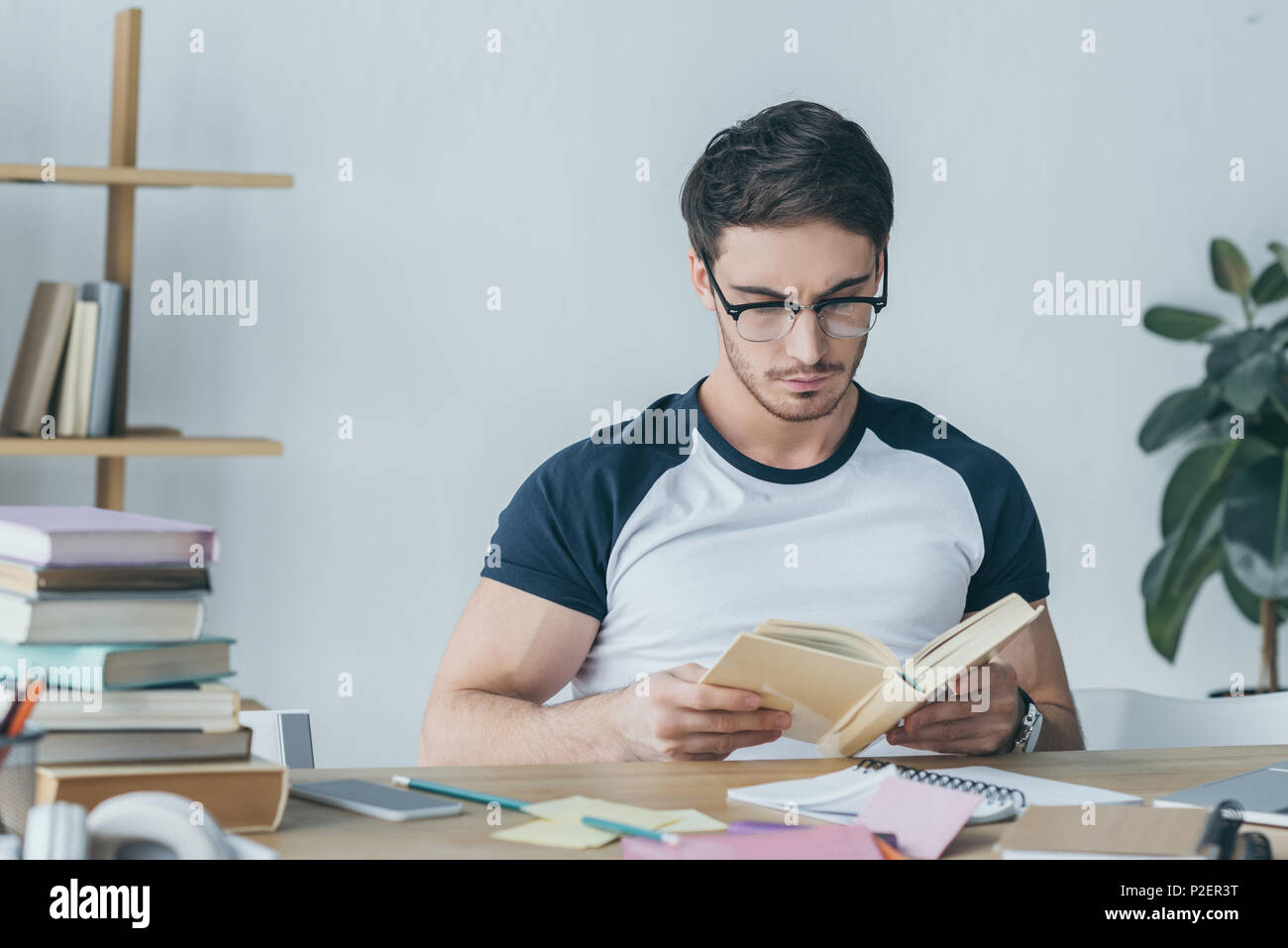 handsome male student reading book Stock Photo - Alamy