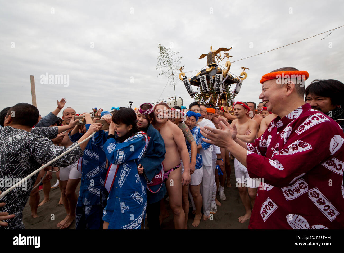 Men dressed in Fundoshi and women dressed in yukata carrying Omikoshi ...