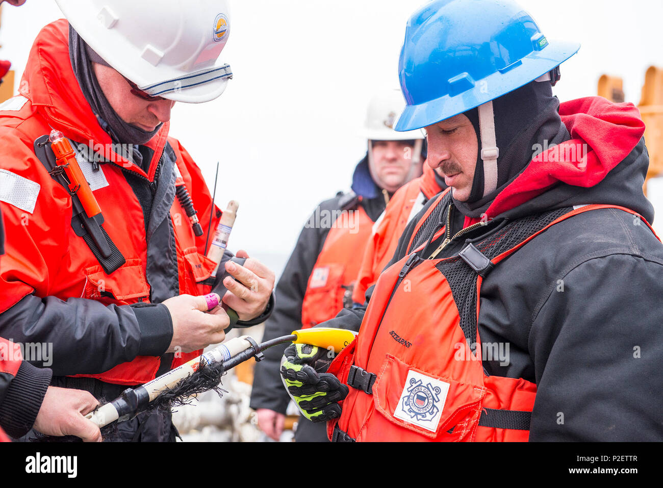 Petty Officer 1st Class David Edelson holds a mooring wire for Scott ...