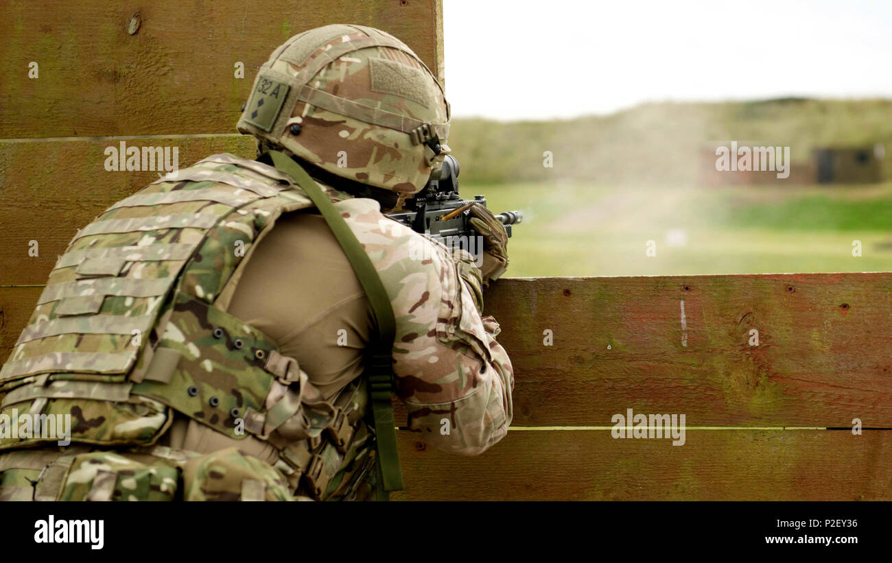 A Royal Marine fires a SA80 A2 rifle in the supported kneeling position ...