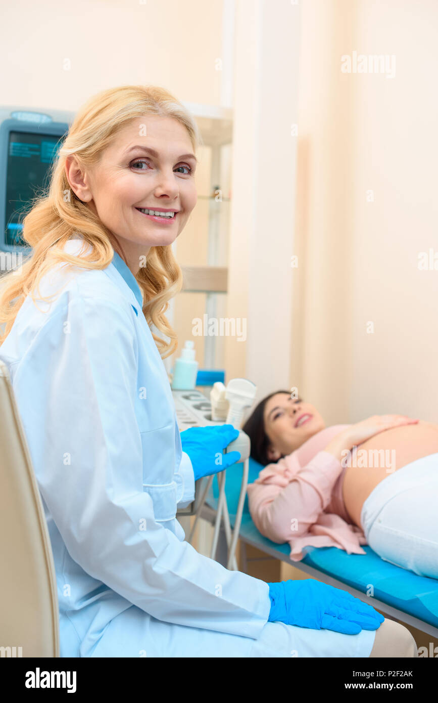 obstetrician gynecologist and pregnant woman in ultrasound examination ...