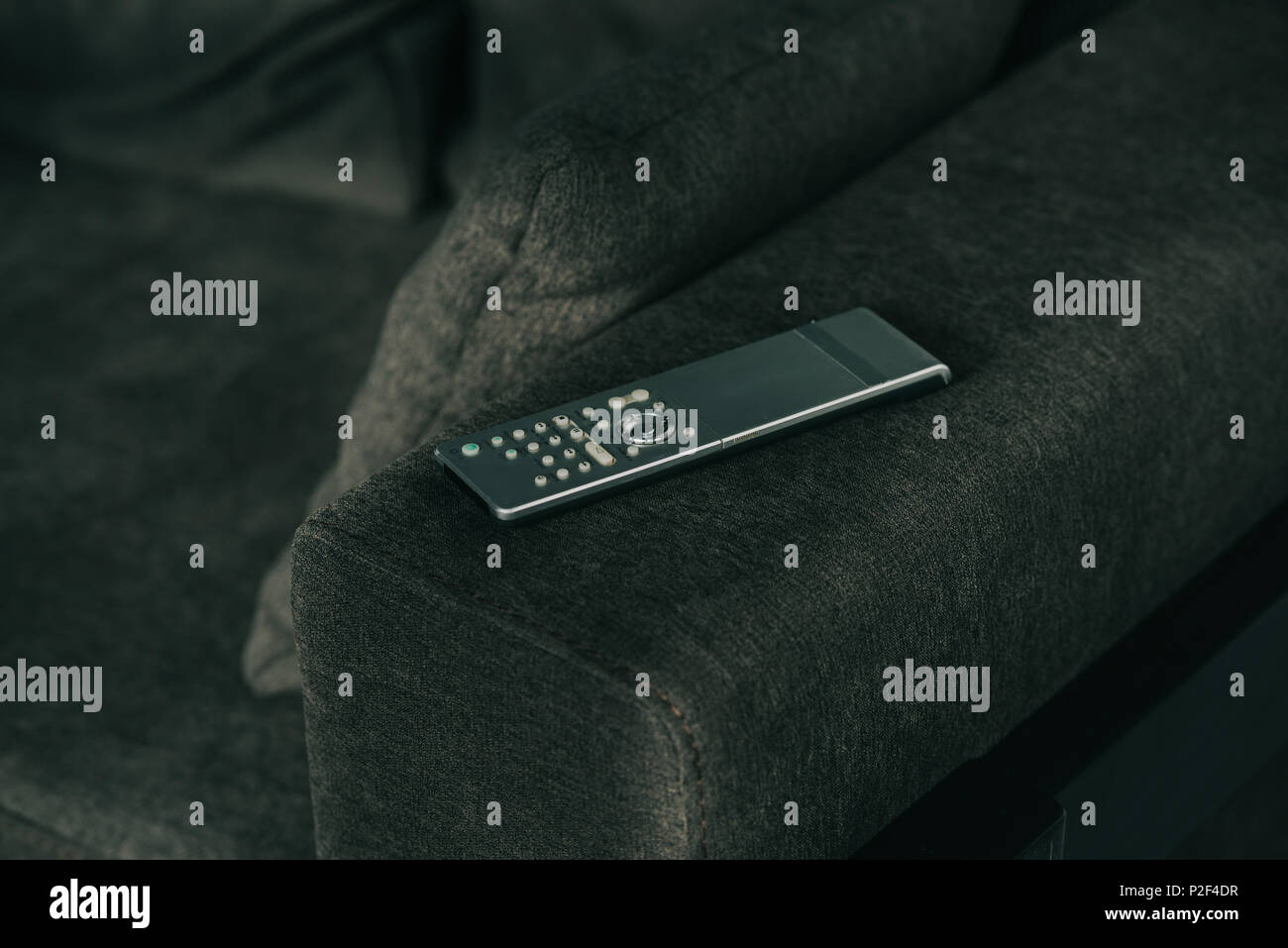 remote control on dark grey sofa Stock Photo - Alamy