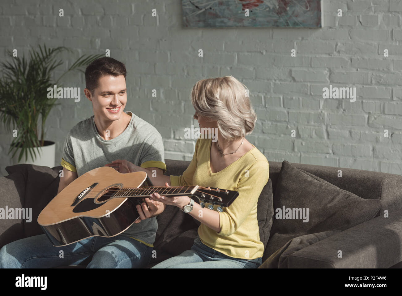 Smiling musician taking guitar hi-res stock photography and images - Alamy