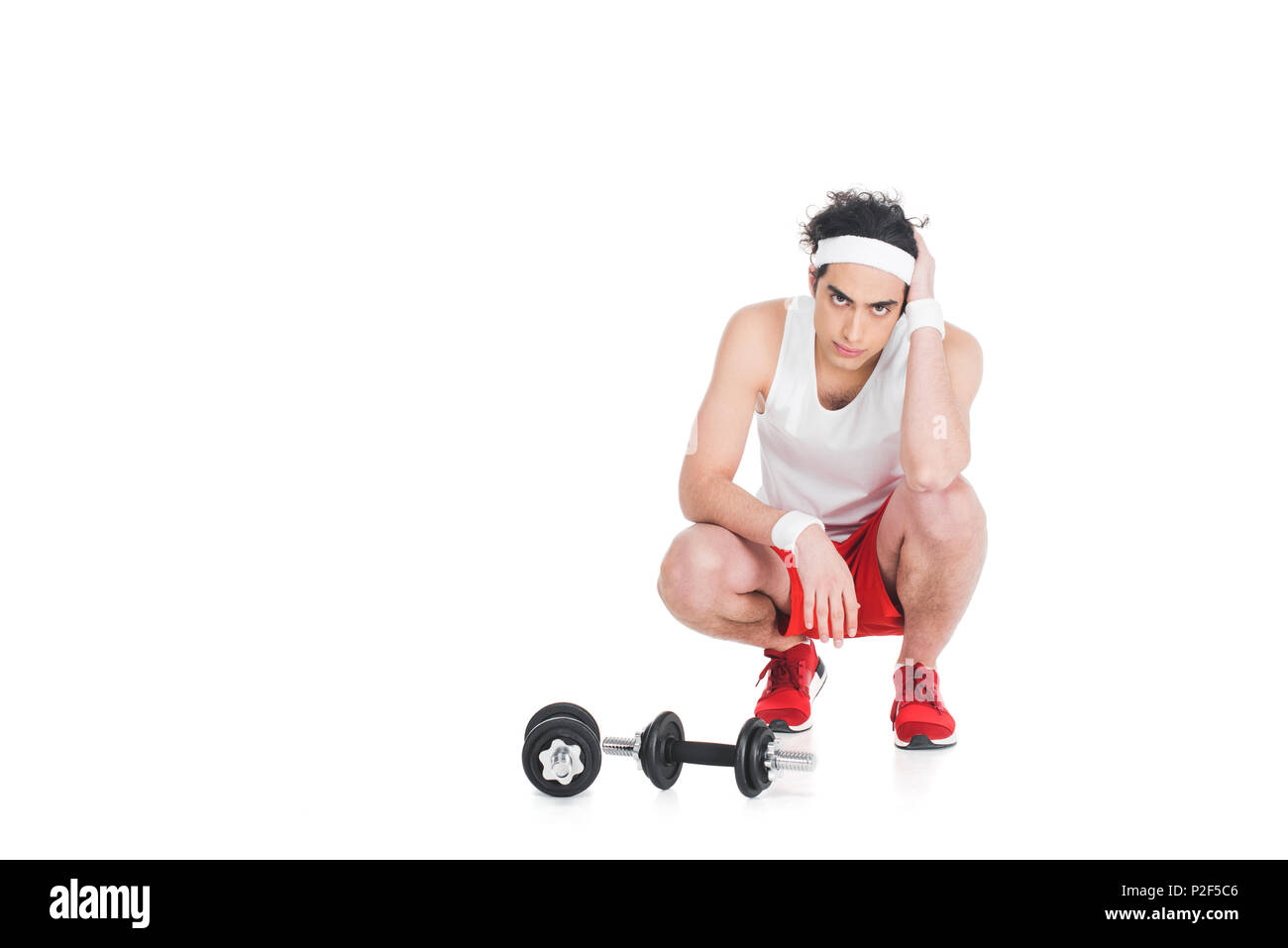 Young skinny man in sportswear sitting near dumbbells Stock Photo - Alamy