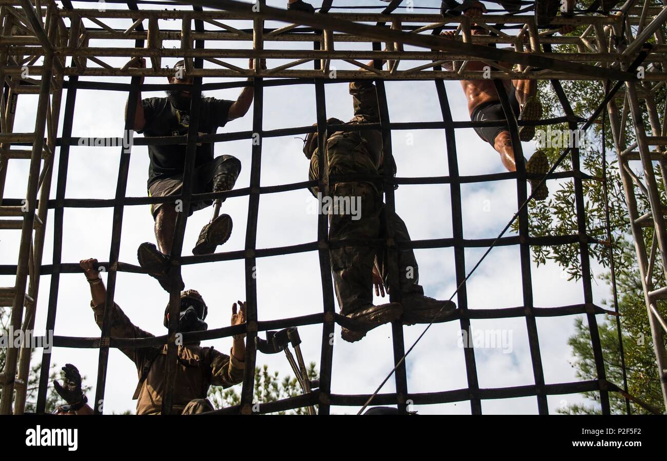 Participants climb the cargo net obstacle during a Spartan Sprint Race ...