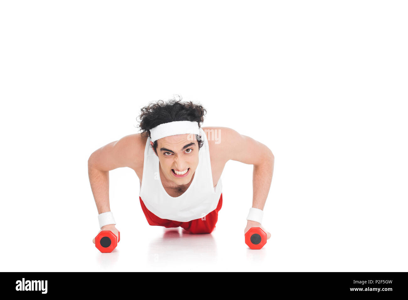 Skinny sportsman doing push ups with dumbbells isolated on white Stock ...