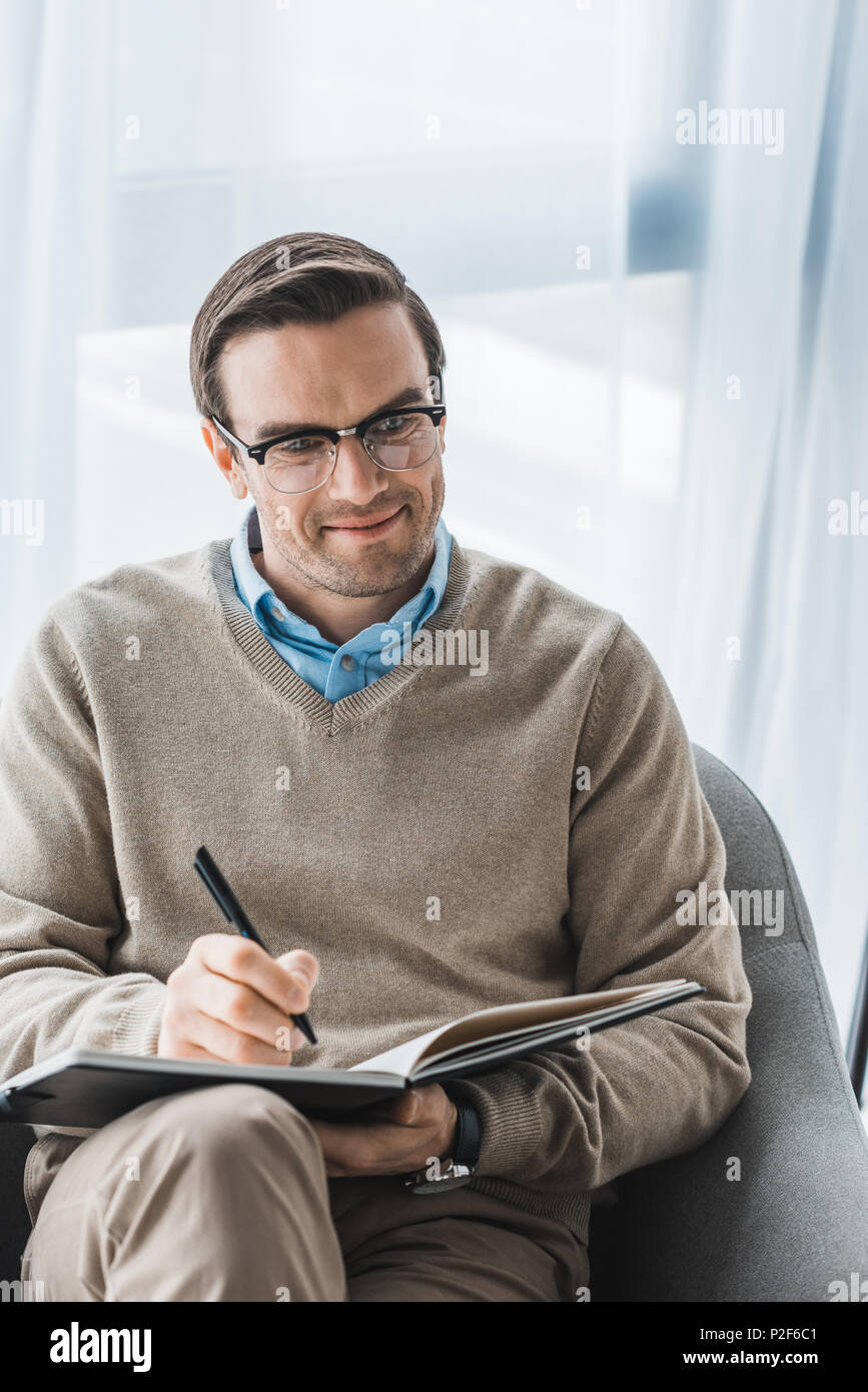 Male psychologist in glasses writing down patient complaints Stock ...
