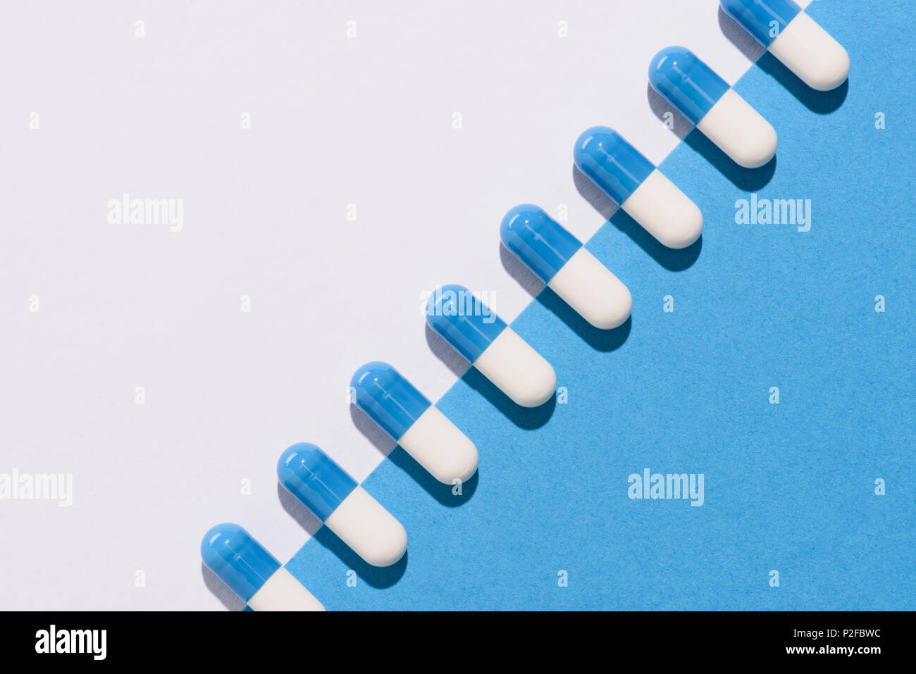 top view of row of pills on halved white and blue surface Stock Photo ...