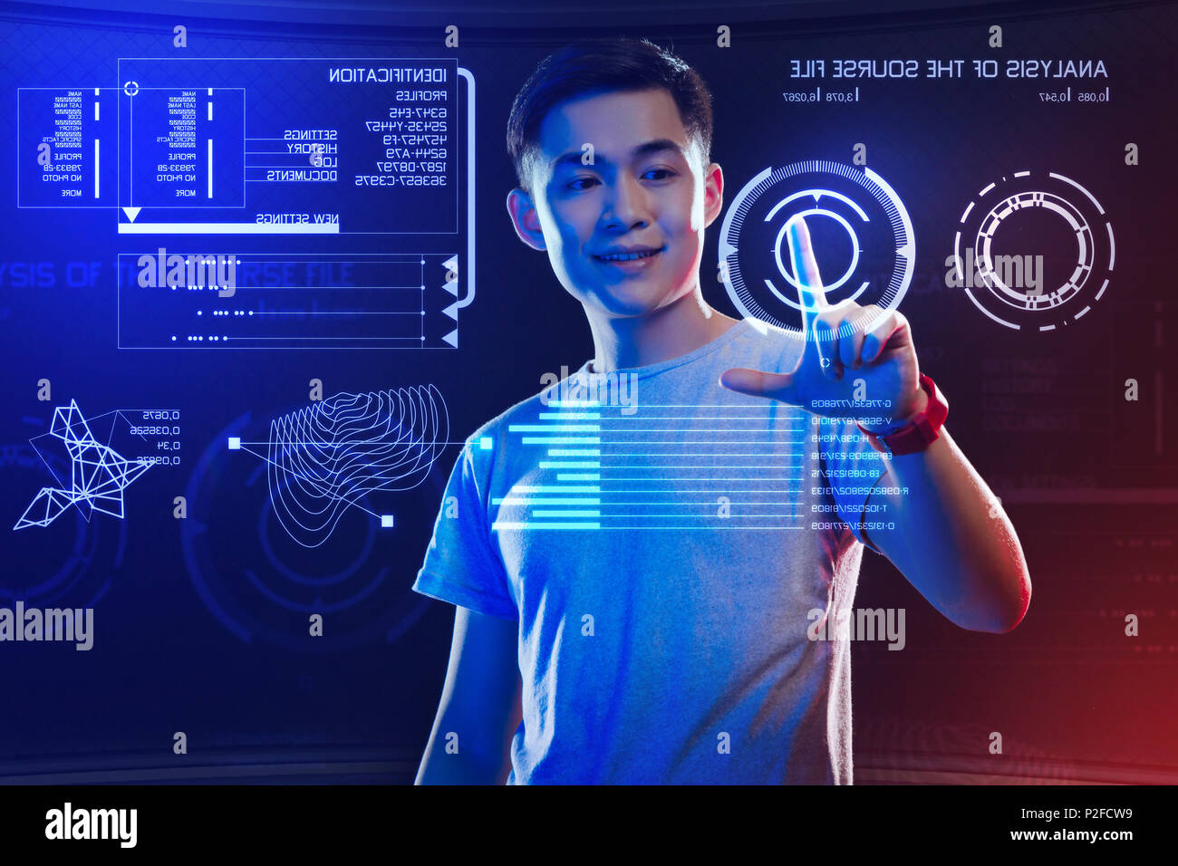 Smiling programmer looking happy while touching visual elements on the screen Stock Photo - Alamy