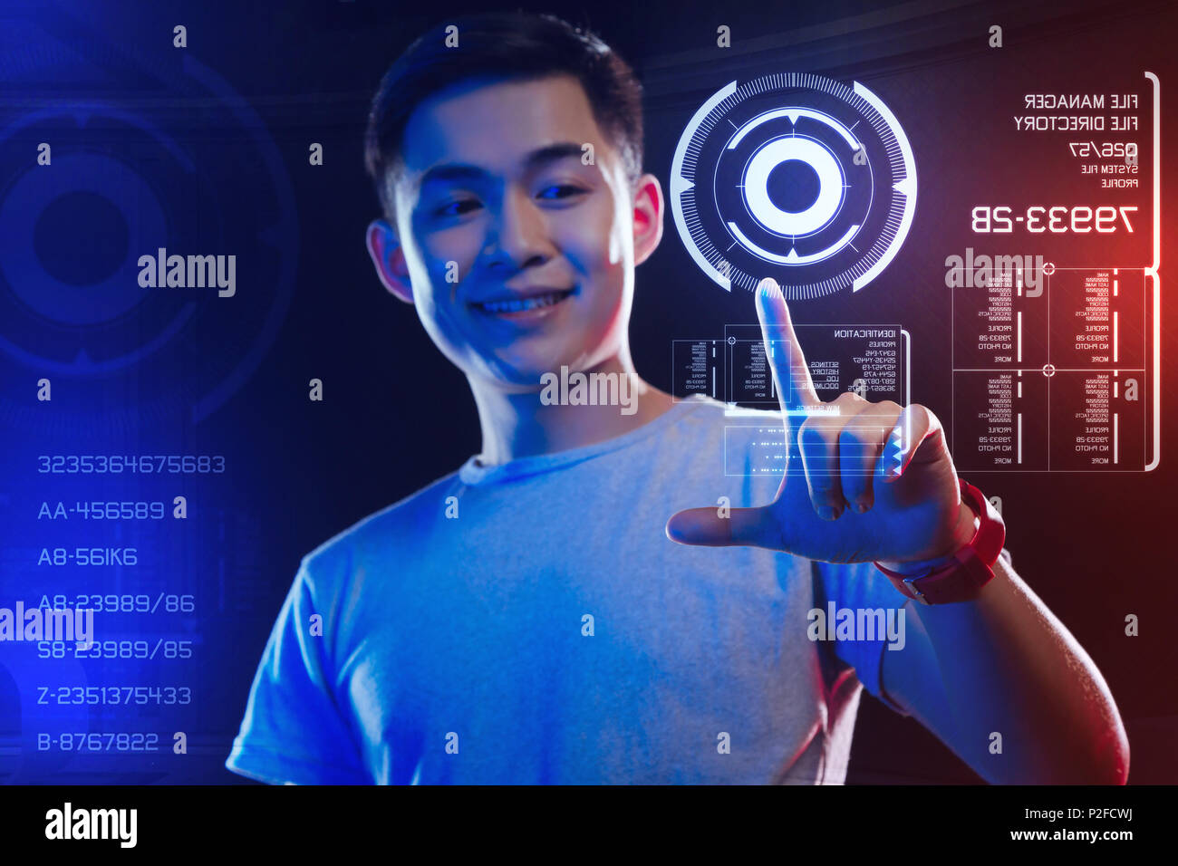 Happy web developer touching a round hologram on the screen and smiling ...