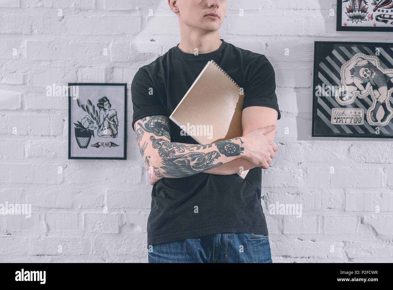 Tattooed man standing by the wall in tattoo studio Stock Photo - Alamy