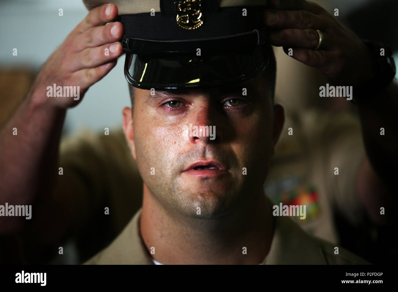 Chief Operations Specialist Nate Klimis holds back tears as a chief ...