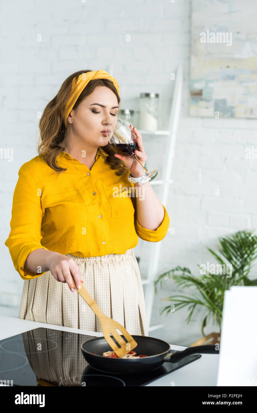 beautiful woman cooking vegetables and drinking red wine Stock Photo ...