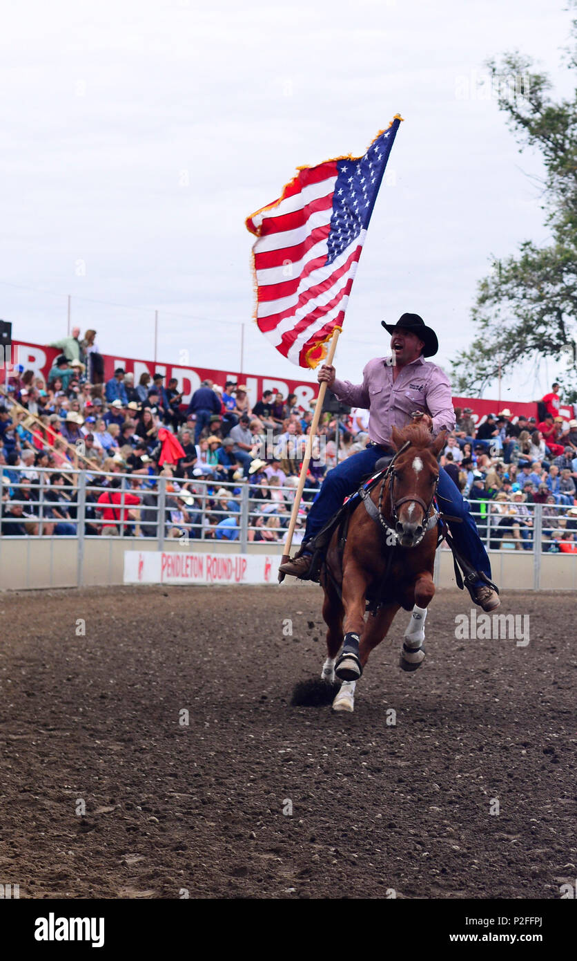 A horseback rider carries the U.S. Flag during the grand entry of the ...