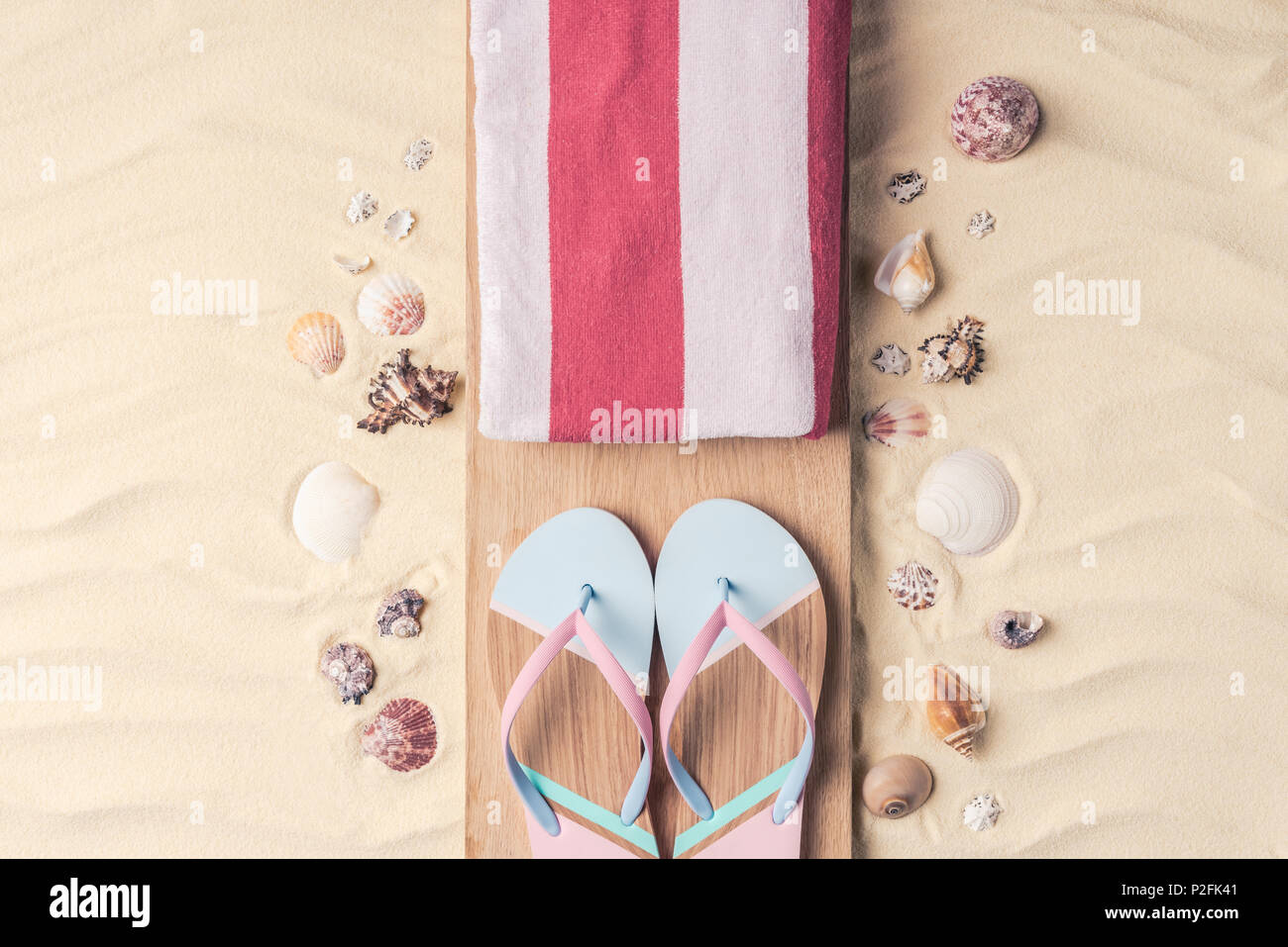 Flip flops and towel with shells on light sand Stock Photo - Alamy