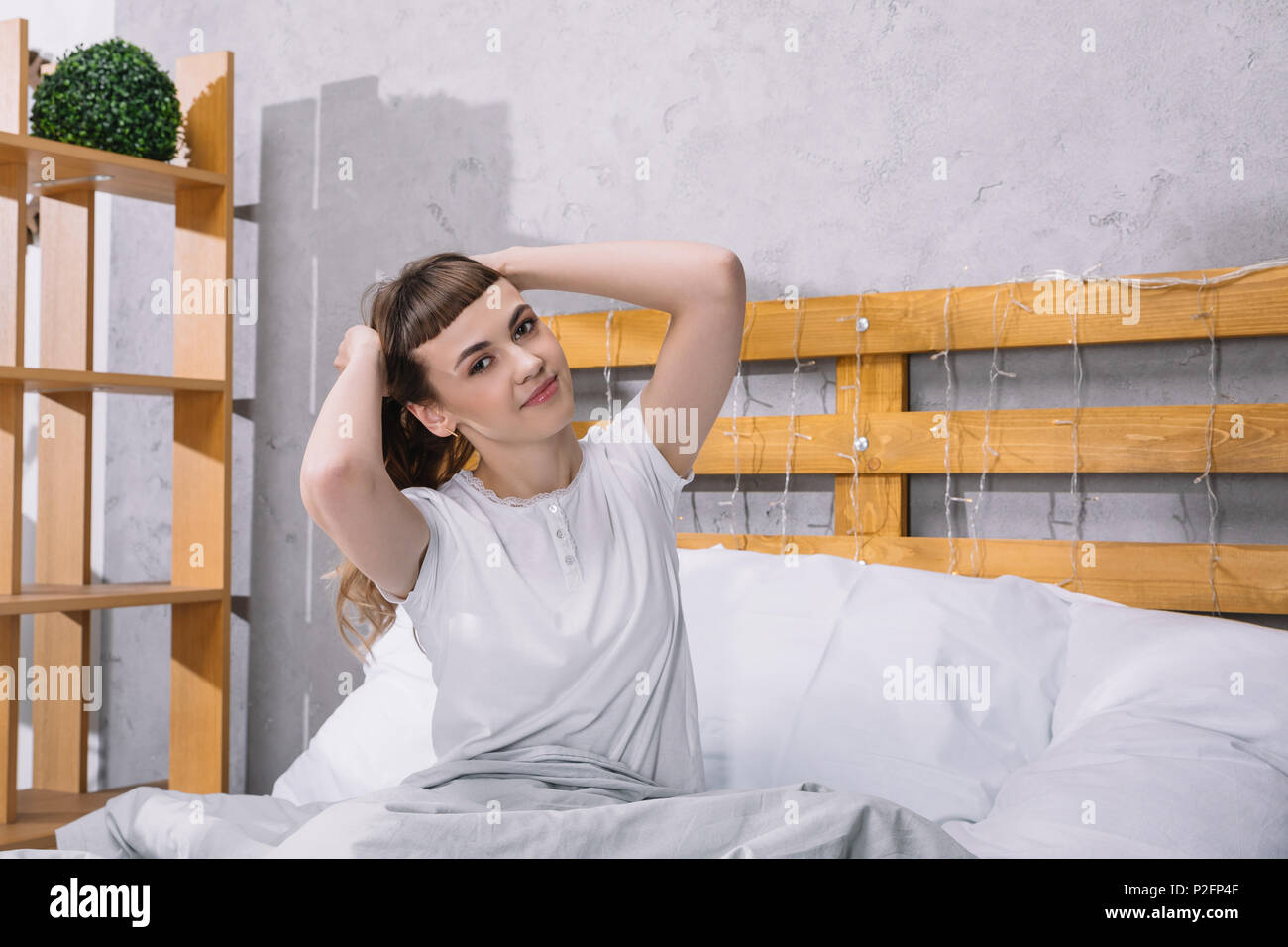 happy girl stretching in bed in morning and looking at camera Stock ...