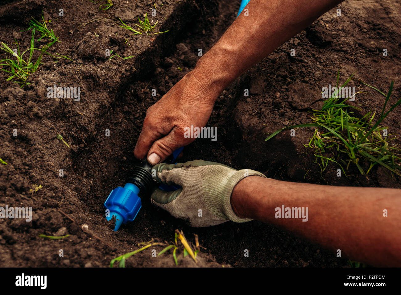 Watering system for a garden in the ground. worker joins pipes Stock ...